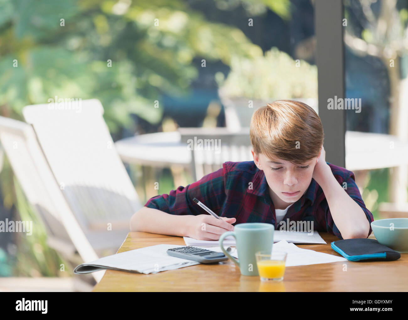 Boy doing math homework at dining table Stock Photo - Alamy