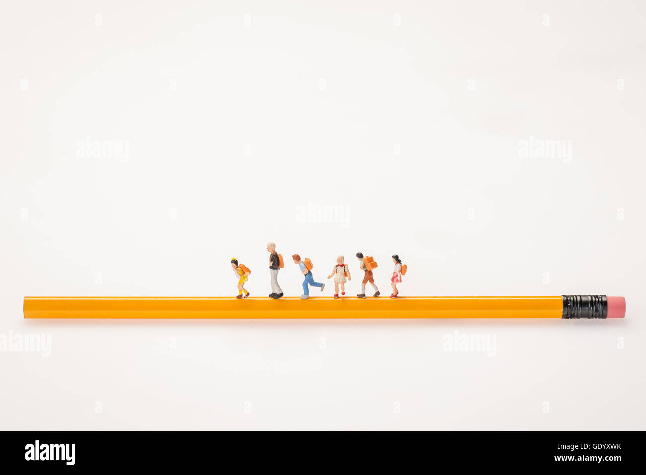 Miniatures of students walking on a pencil Stock Photo - Alamy