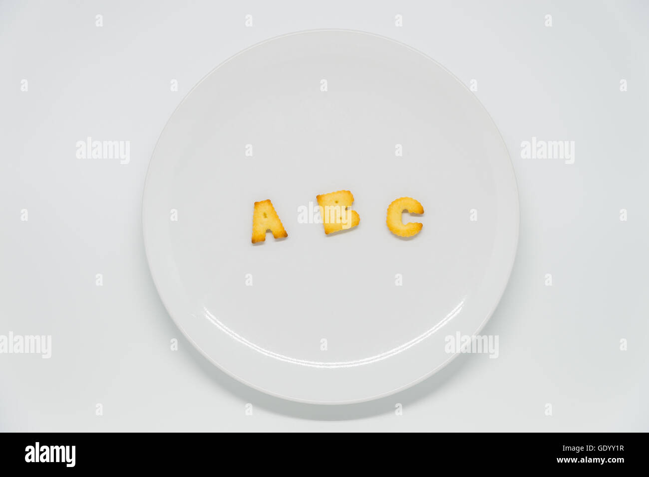 ABC alphabet cracker on dish with white background Stock Photo - Alamy