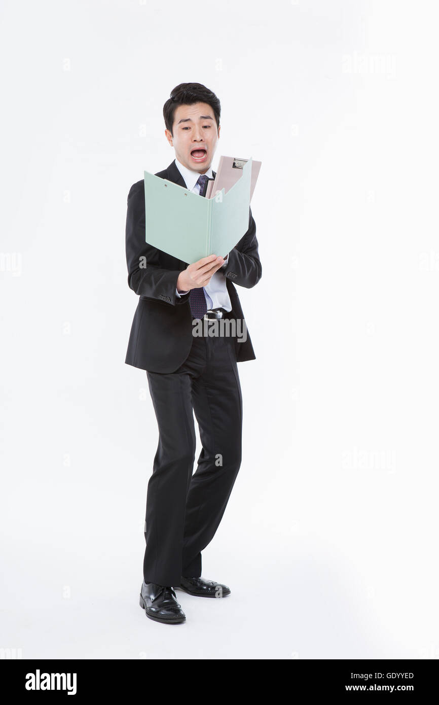Surprised business man with files standing Stock Photo - Alamy