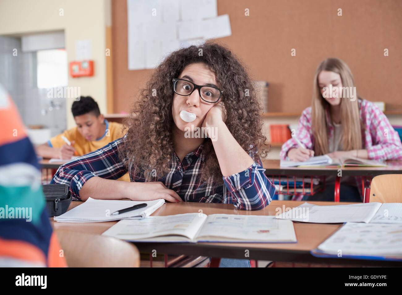 University student blowing bubblegum in classroom, Bavaria, Germany ...