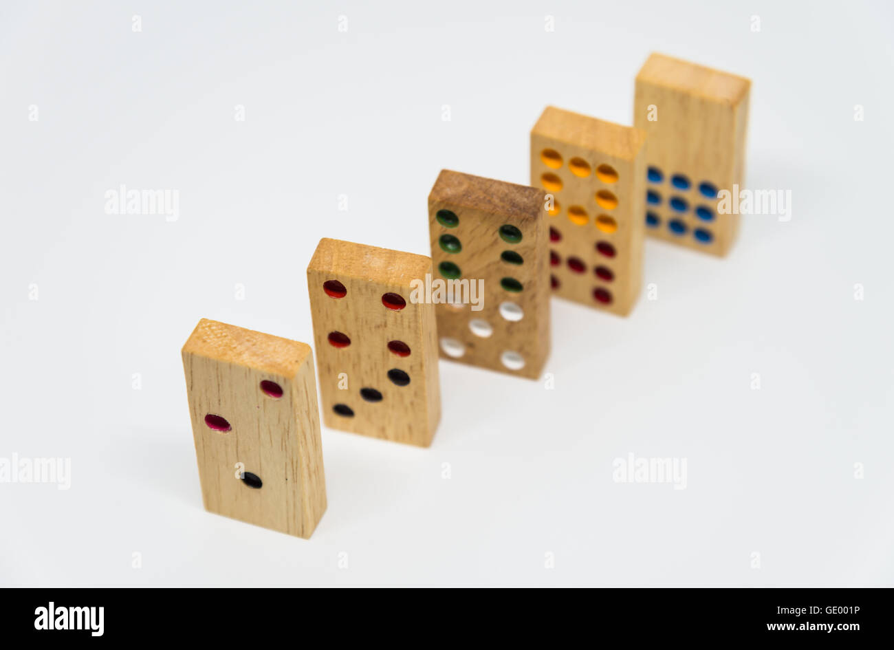 Sequence of wooden dominoes on white background with selective focus ...