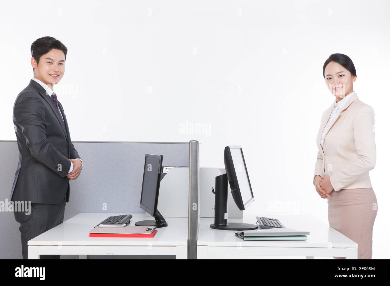 Young businessman and businesswoman standing face to face smiling at ...