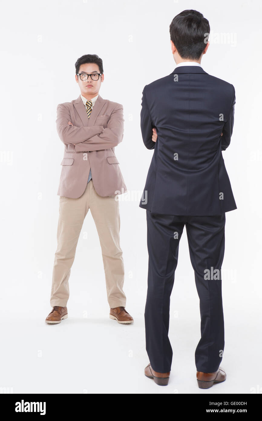 Two businessmen standing face to face with their arms folded Stock ...