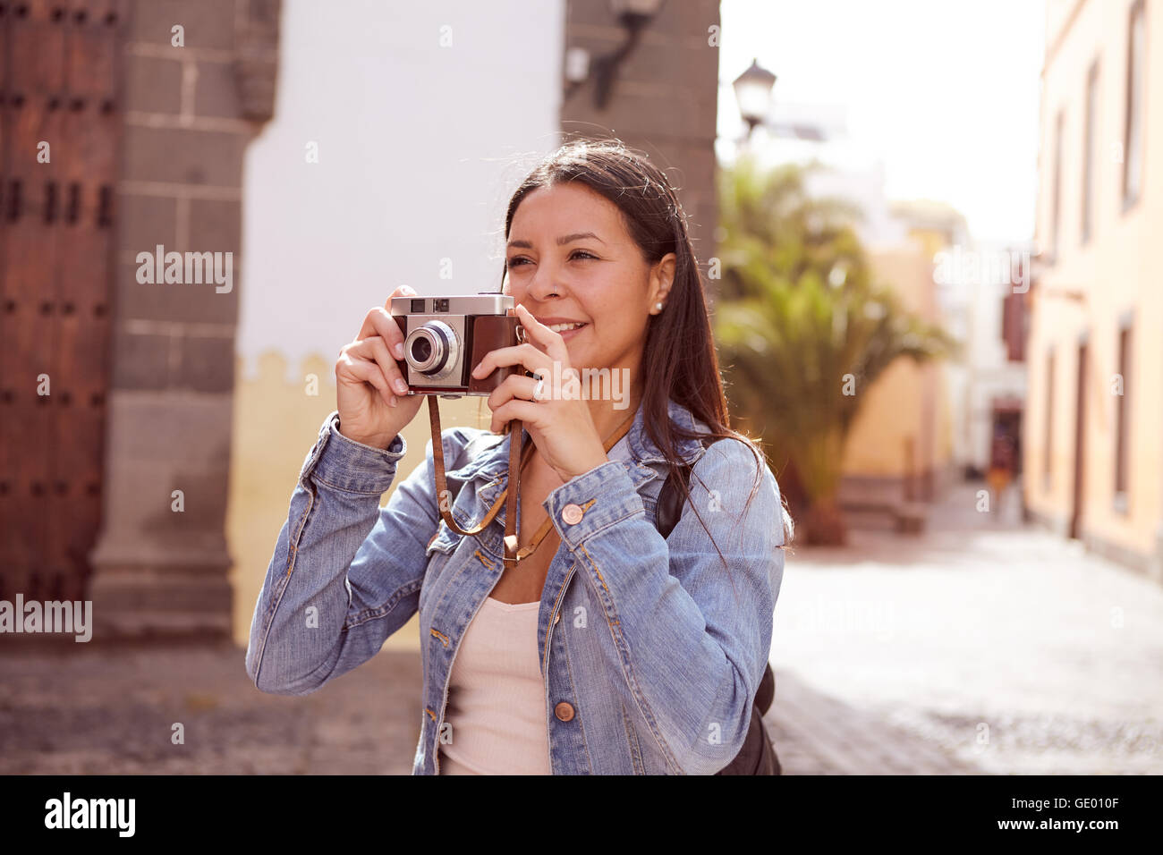 Pretty young girl taking pictures, smiling with her camera wearing her ...