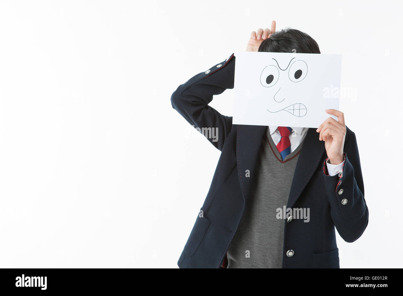 Portrait of school boy covering his face with an angry mask Stock Photo ...