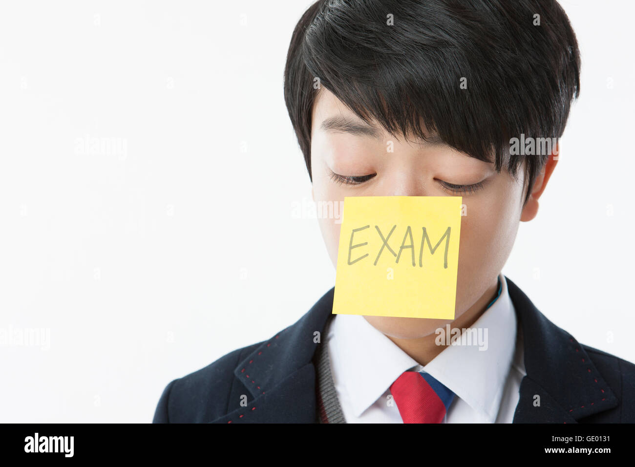 Portrait of school boy with word of EXAM on his face looking down Stock ...