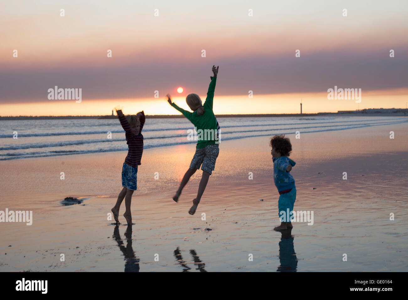 Family Together Jumping In Water At Beach High Resolution Stock ...