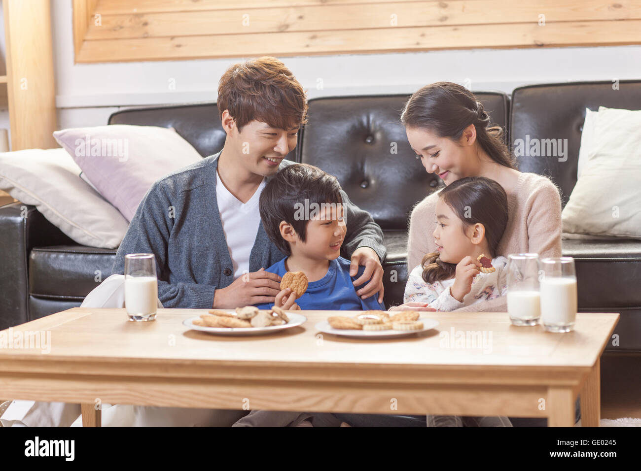 Harmonious family having a snack time in living room Stock Photo - Alamy