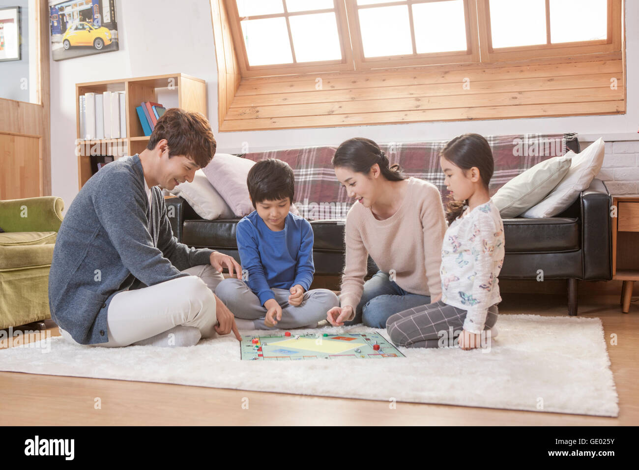 Harmonious family playing a board game together in living room Stock ...