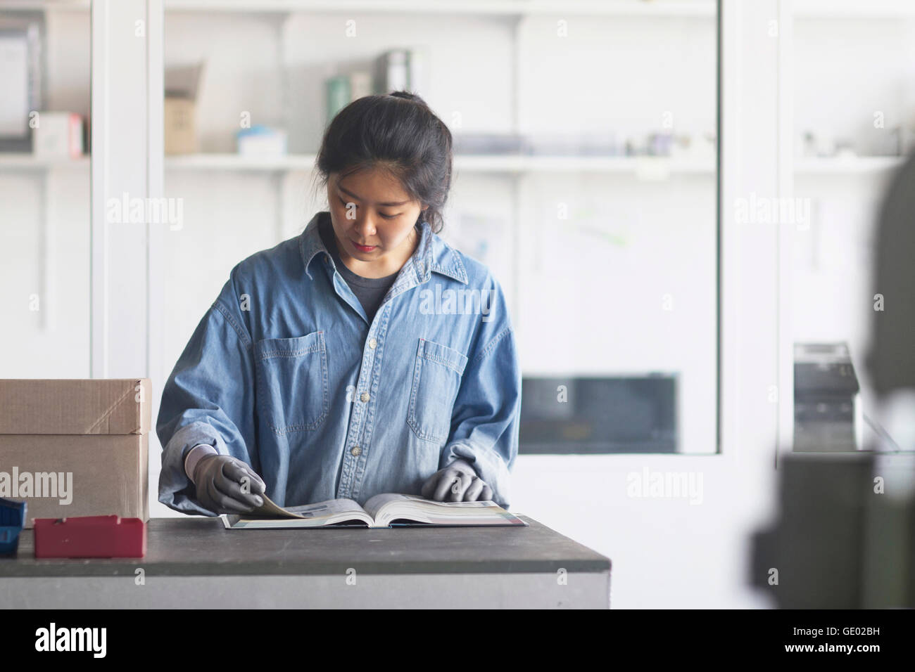 Young female engineer reading book in an industrial plant, Freiburg im ...
