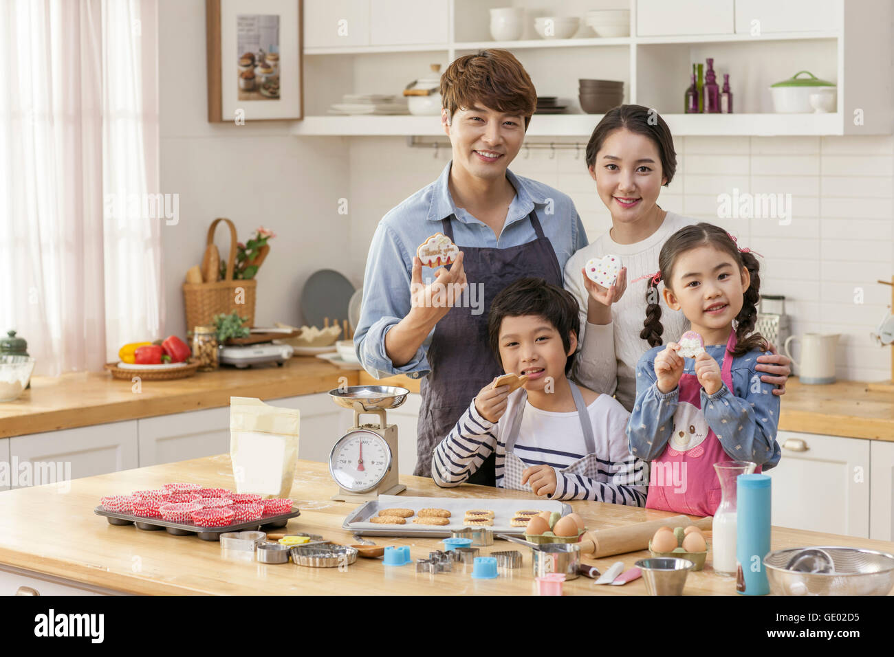 Harmonious family eating cookies together in kitchen Stock Photo - Alamy