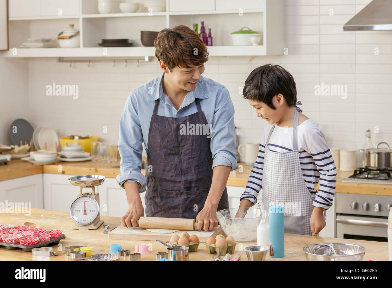 Smiling father and son cooking together in kitchen Stock Photo - Alamy