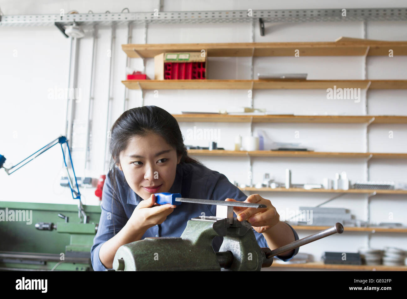 Young female engineer grinding metal in an industrial plant, Freiburg ...