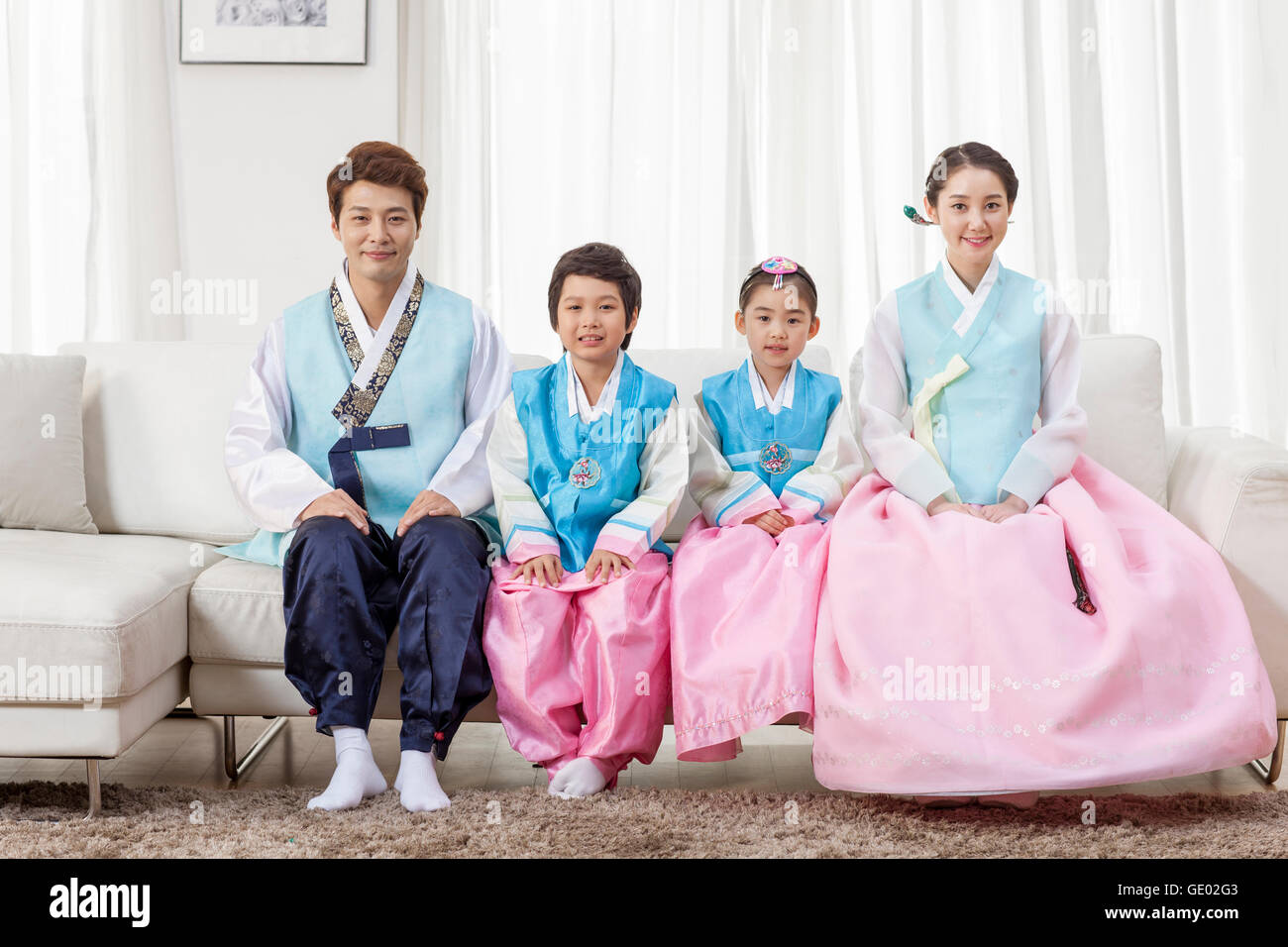 Harmonious family in traditional Korean clothes sitting on a sofa Stock ...
