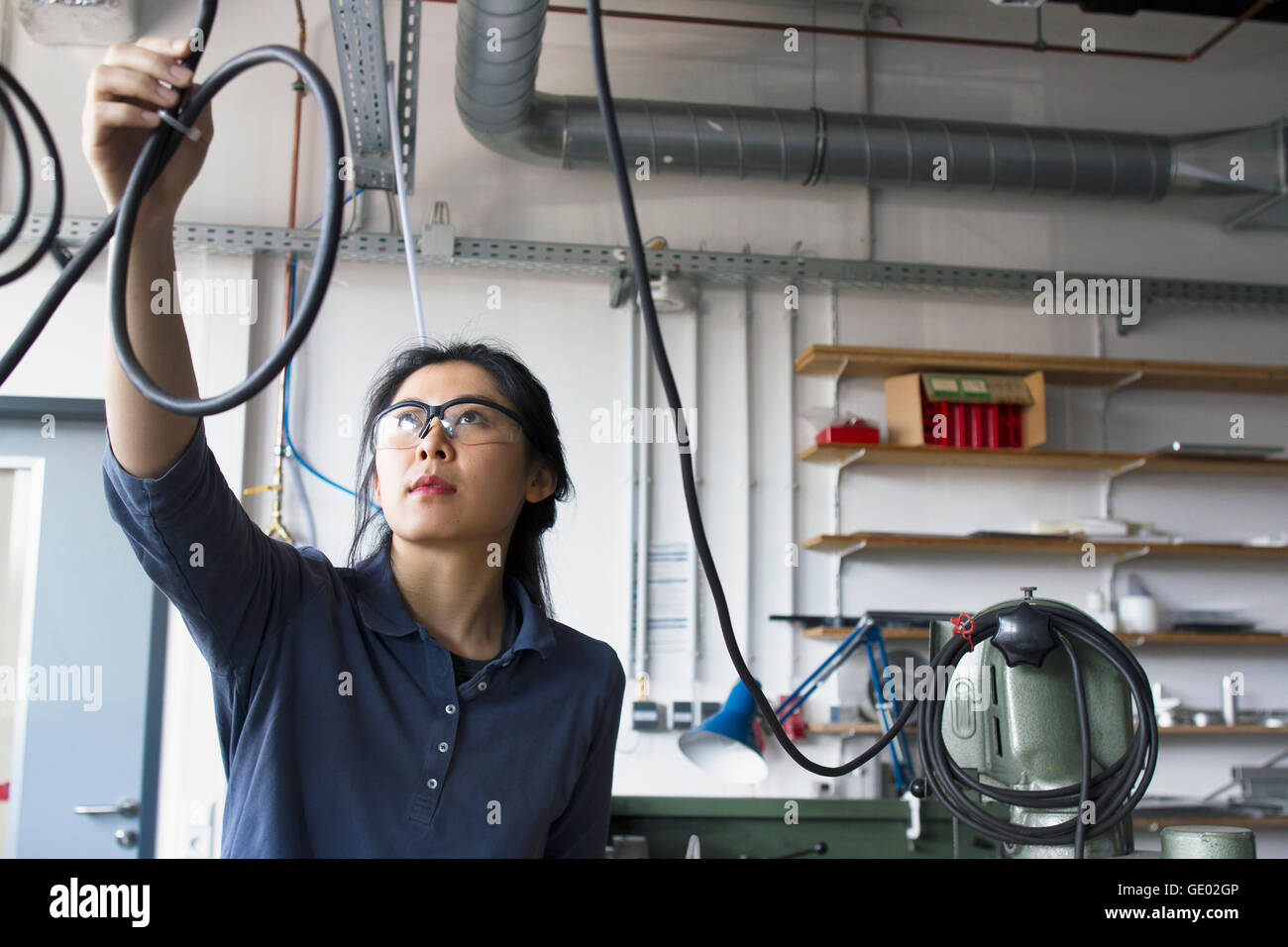 Young female engineer checking cables in an industrial plant, Freiburg ...