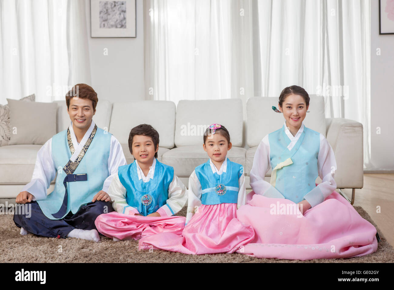 Harmonious family in traditional Korean clothes sitting down on a ...