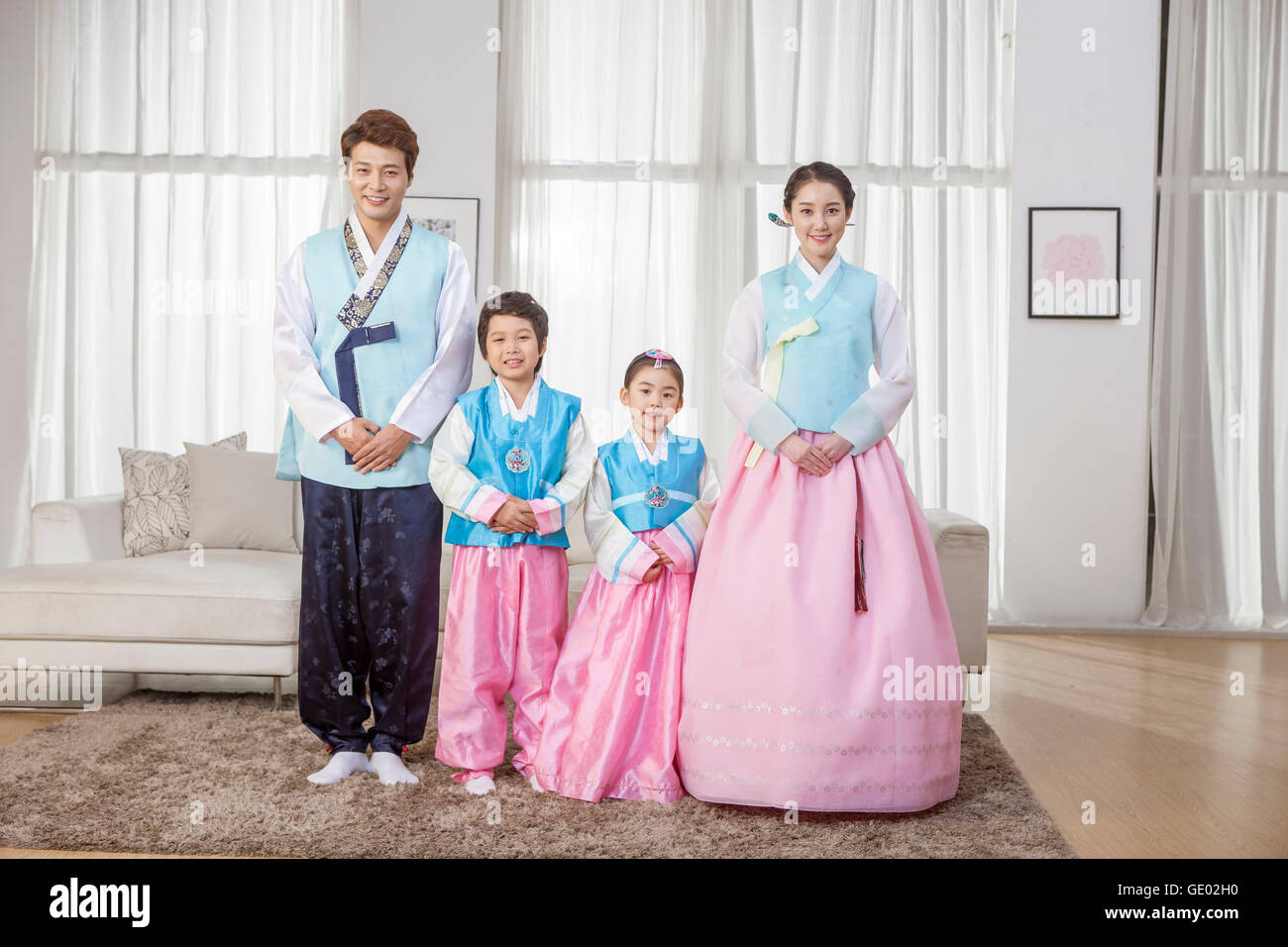 Harmonious family in traditional Korean clothes standing with hands ...