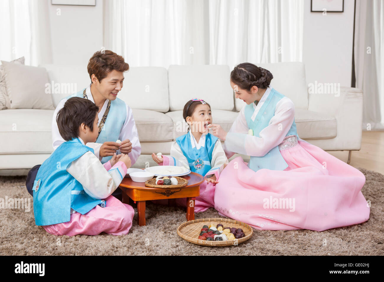 Harmonious Korean family making and eating rice cake Stock Photo - Alamy