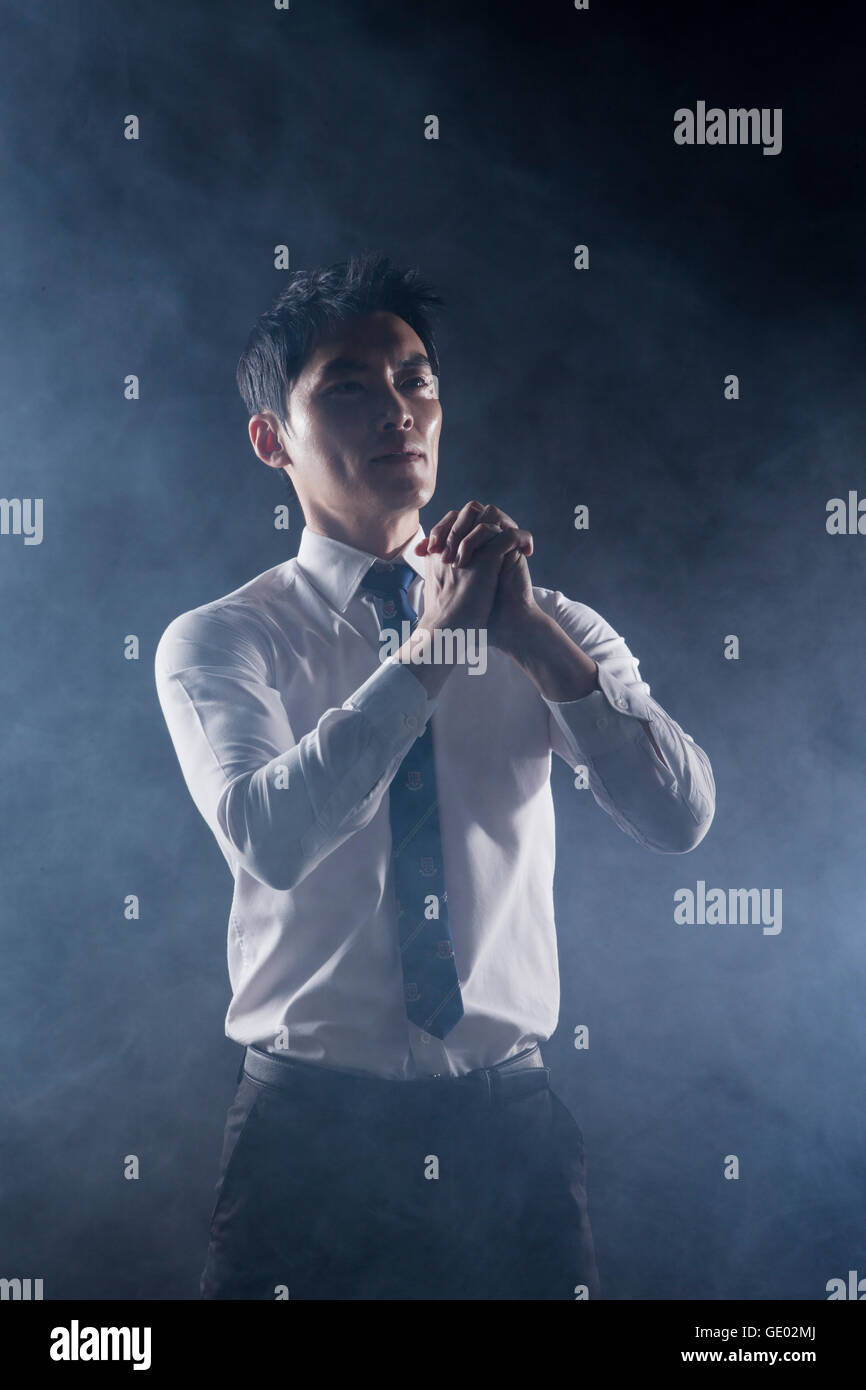 Serious business man folding his hands Stock Photo - Alamy