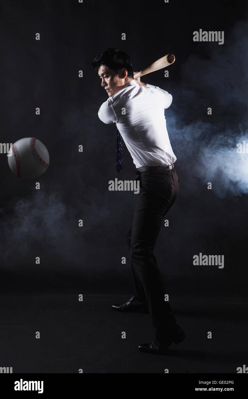 Side view of businessman standing swinging a baseball bat Stock Photo ...