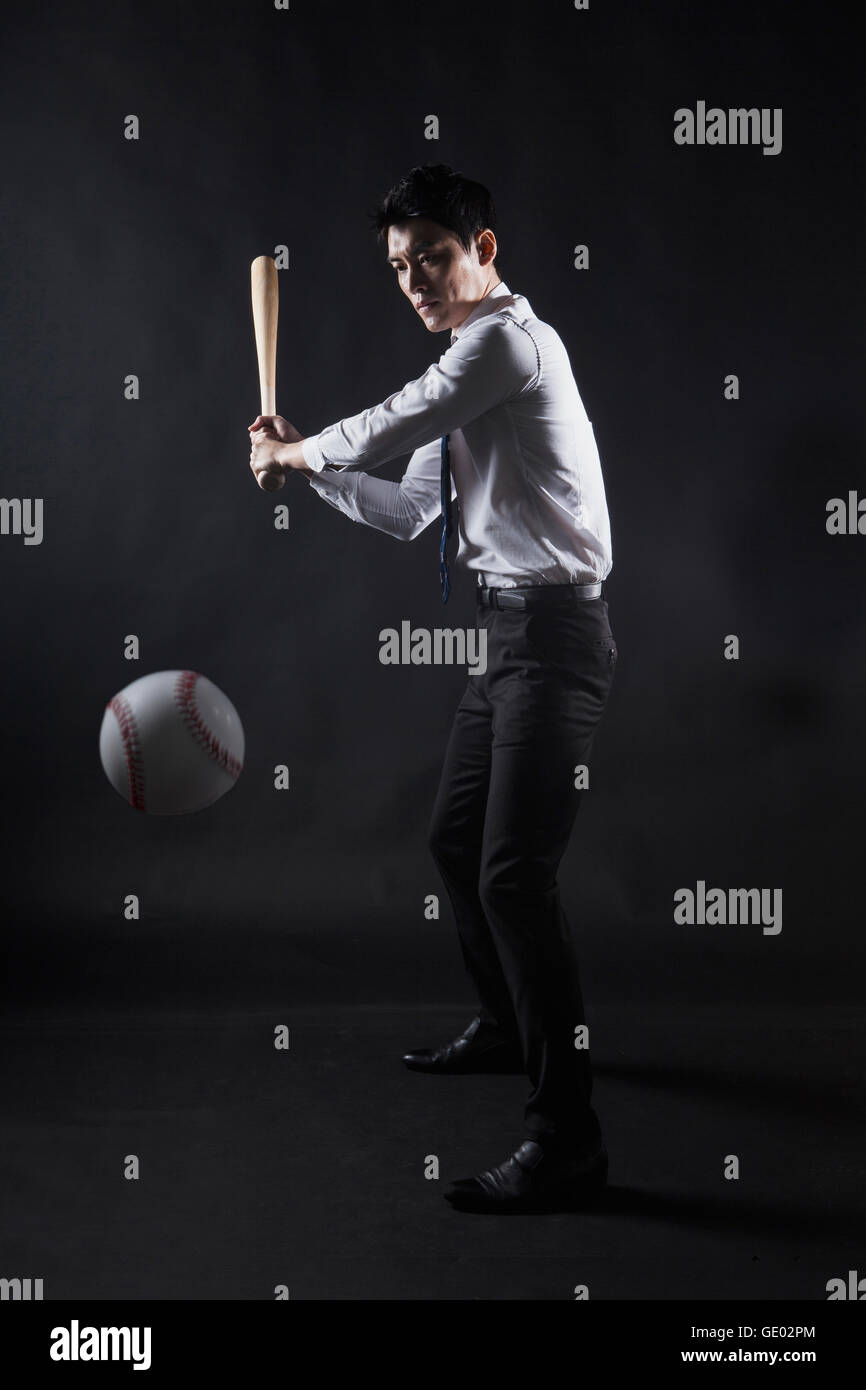 Side view of business man standing and swinging a baseball bat Stock ...