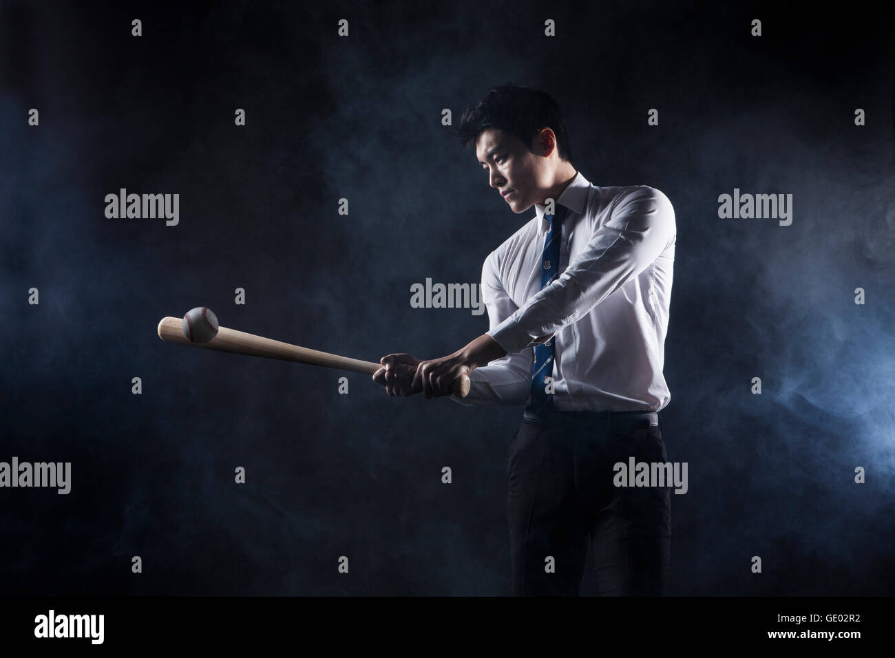 Side view portrait of business man hitting a baseball with a bat Stock ...