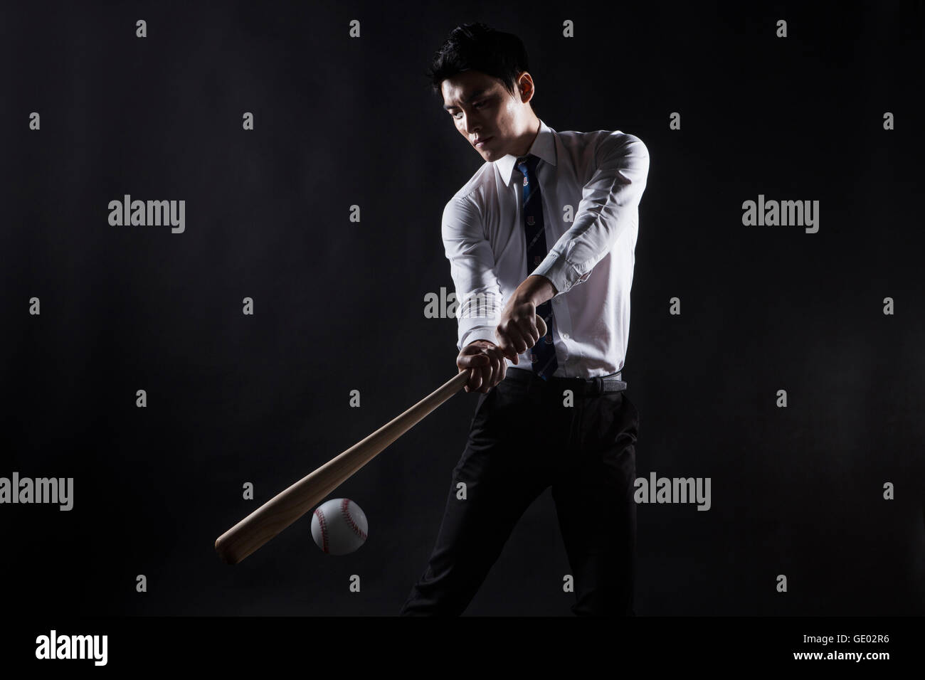 Side view portrait of business man hitting a baseball with a bat Stock ...
