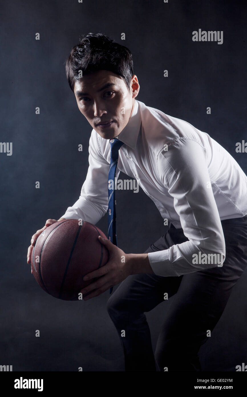 Business man posing with a basketball staring at front Stock Photo - Alamy