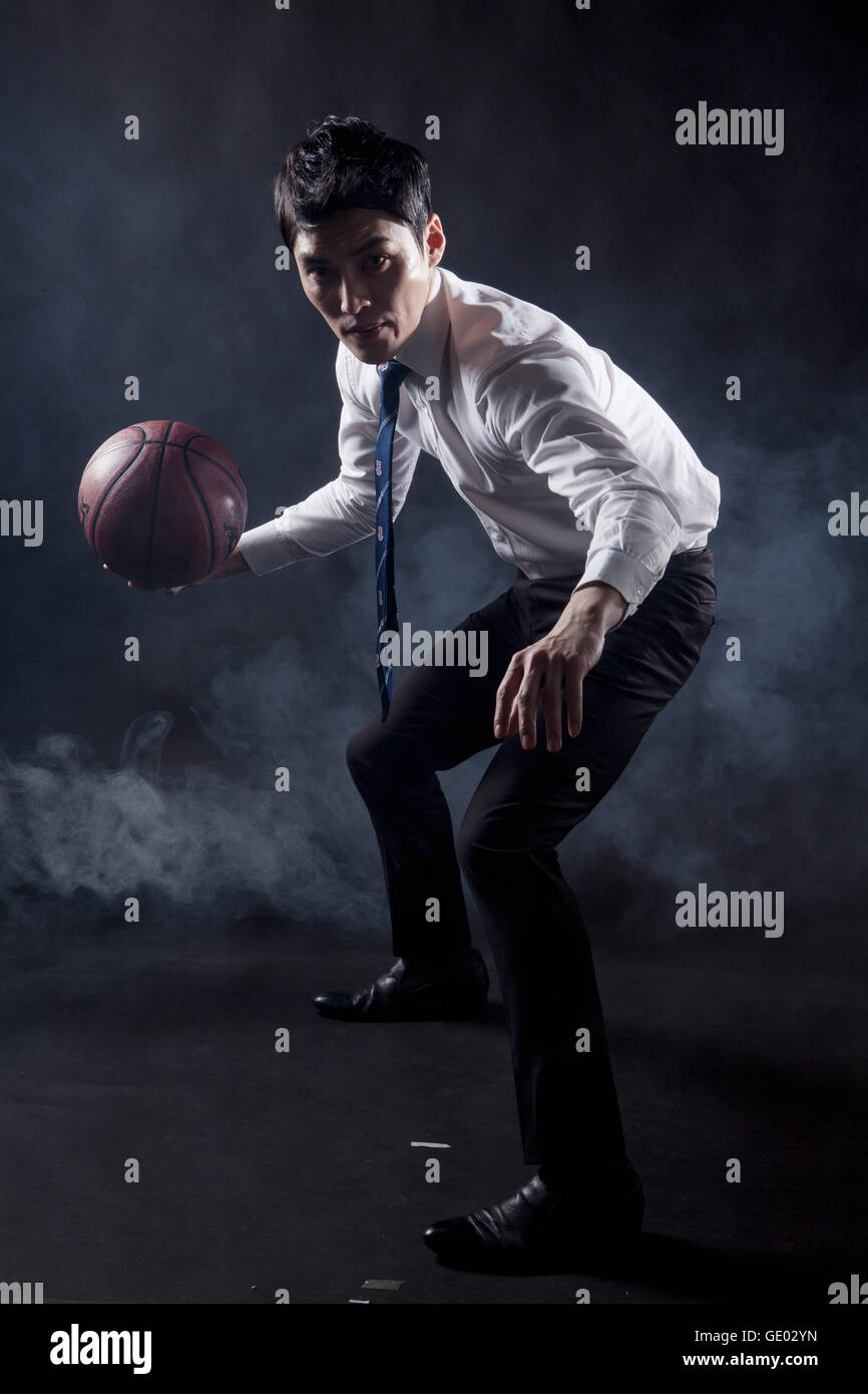 Business man posing with a basketball staring at front Stock Photo - Alamy