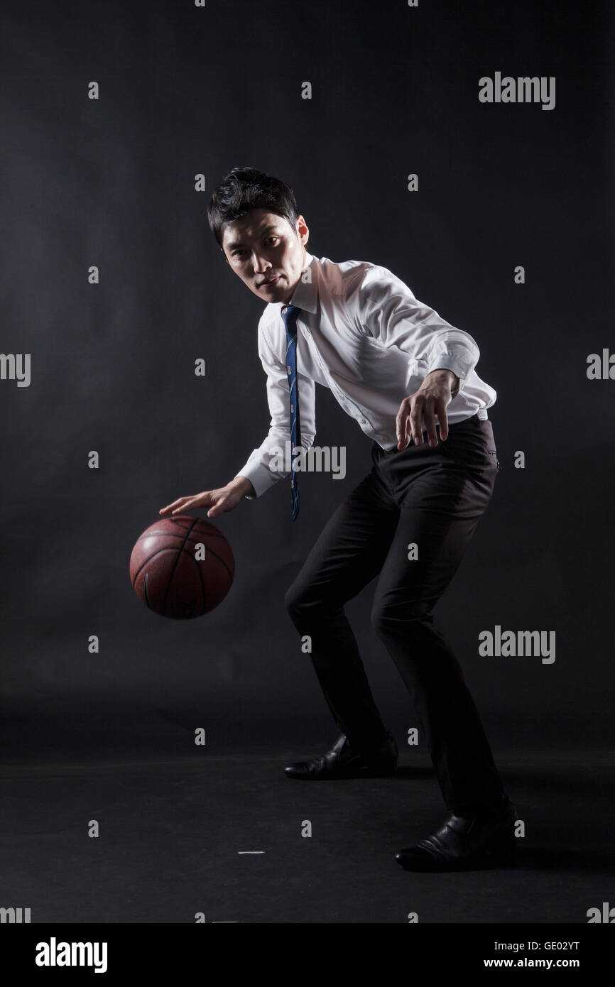 Business man dribbling a basketball staring at front Stock Photo - Alamy