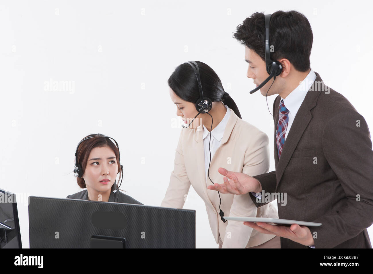 Three young worried business people wearing headphones face to face ...