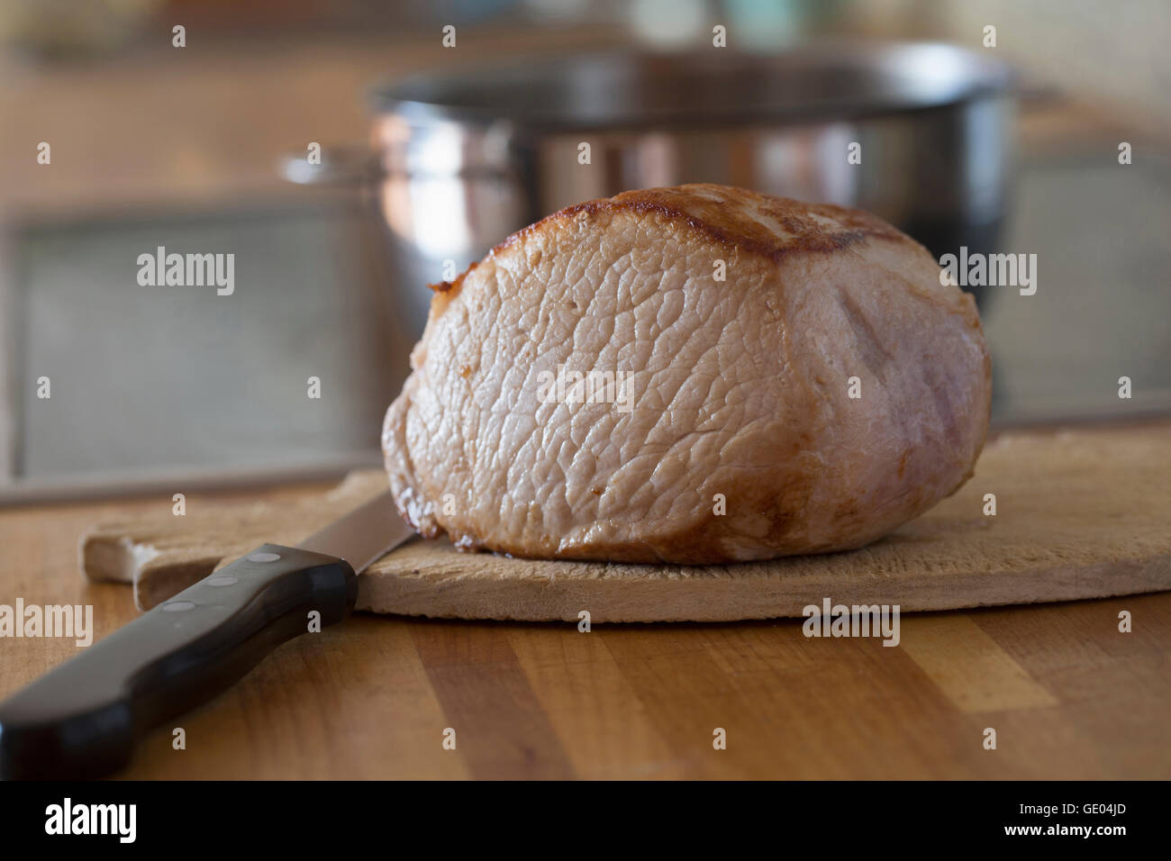 Roast pork and knife on kitchen worktop Stock Photo - Alamy