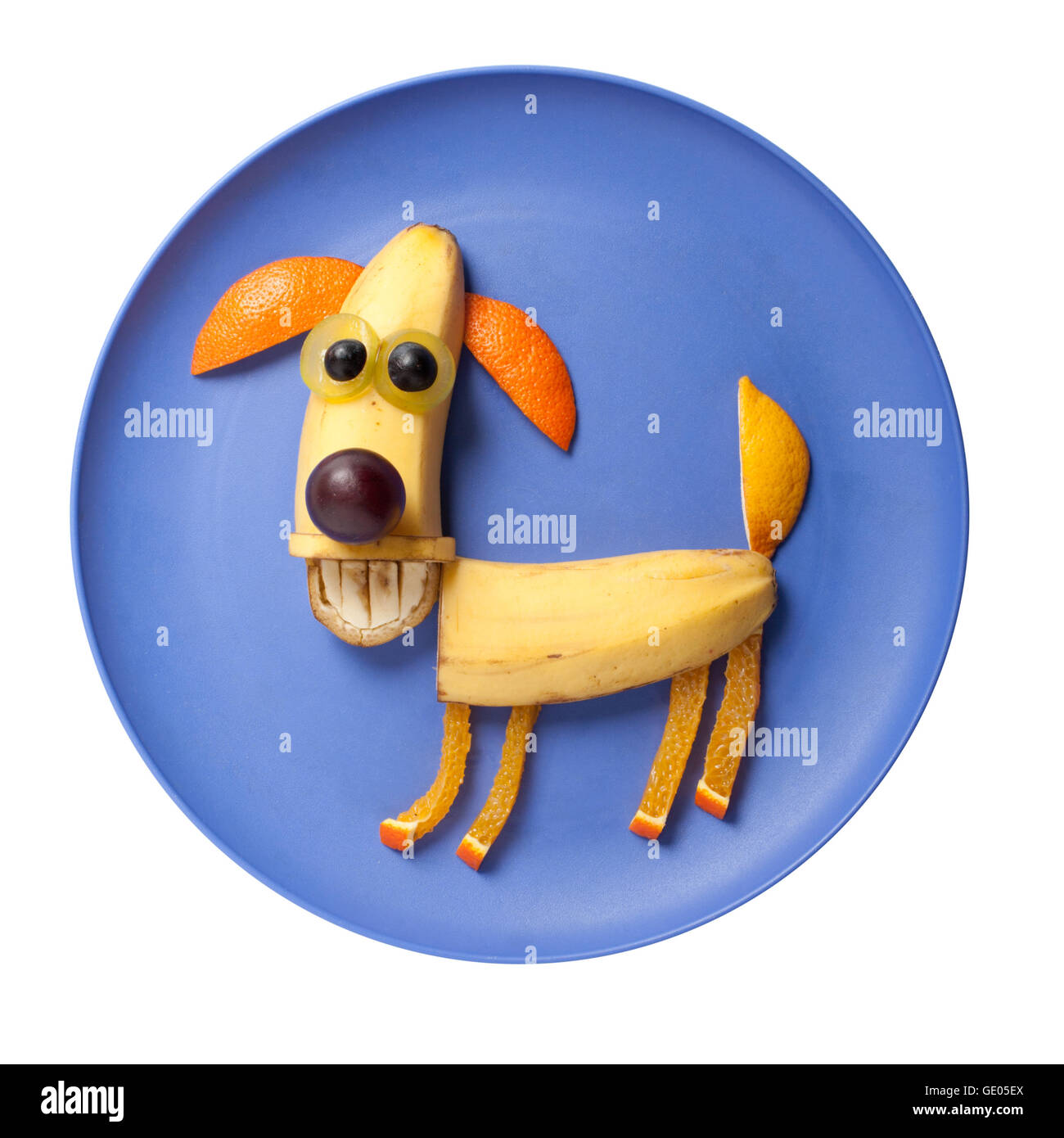 Happy dog made of fruits on blue plate Stock Photo - Alamy