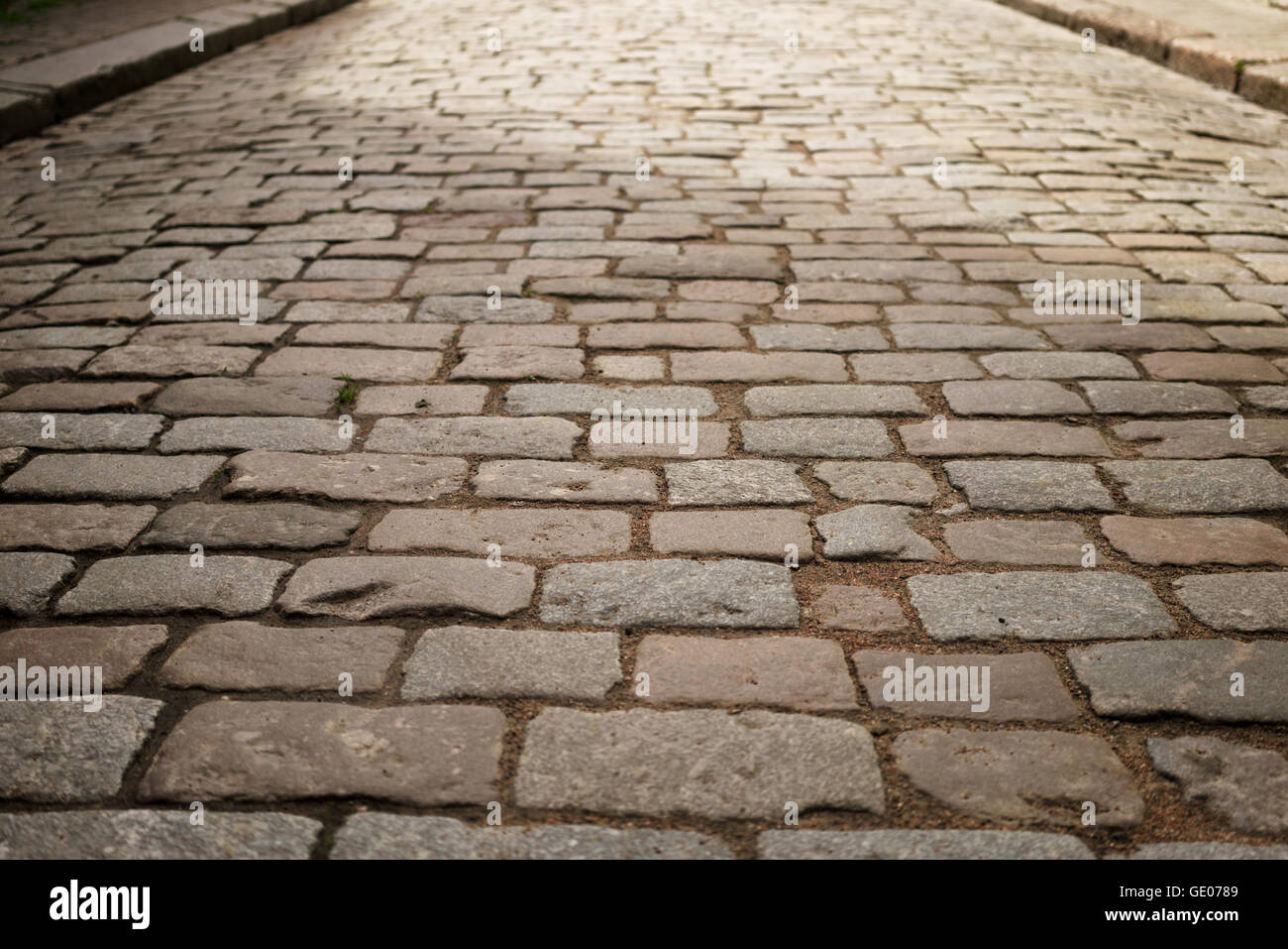 perspective view of old paved road in town Stock Photo - Alamy