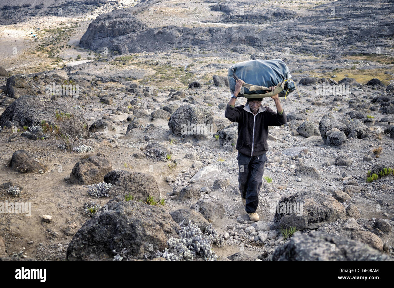Porter carrying a bag on his head above Moir Hut Camp, Mount ...
