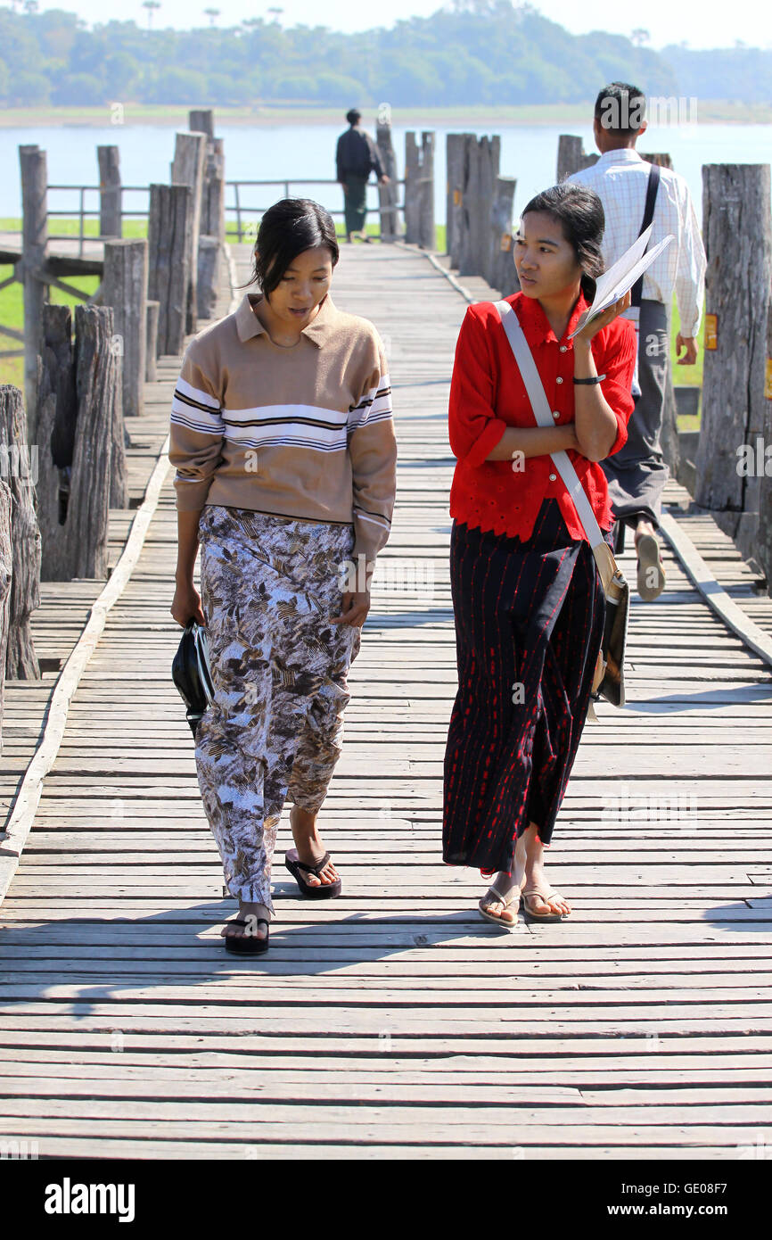 Women walking on the famous teak bridge (U Bein Bridge) in Mandalay ...