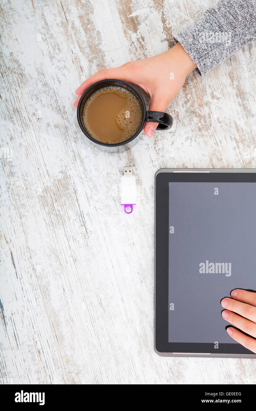 A woman’s hand at a table useing a tablet Stock Photo - Alamy
