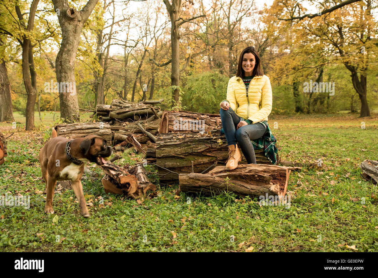 Beautiful young woman enjoying the autumn in the forest with her dog ...
