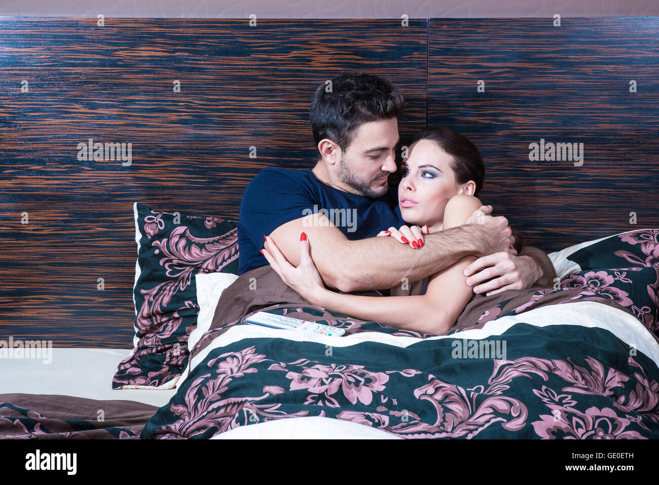 Beautiful young couple being scared in the bedroom Stock Photo - Alamy