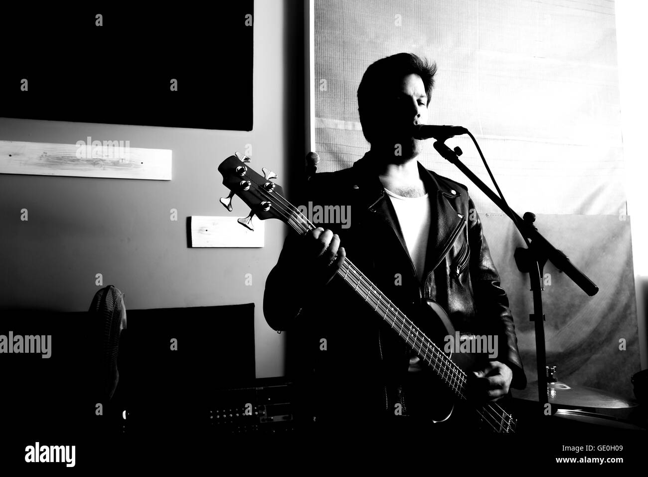 A Rock musician playing passionately bass in the rehearsal Studio Stock ...