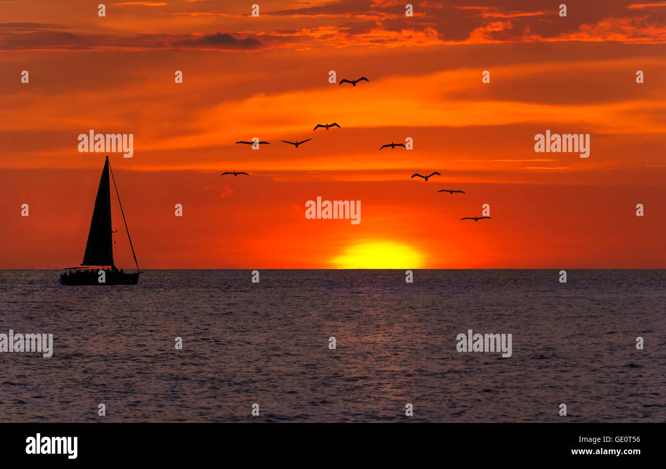 Ocean sunset sailing fantasy is a bright yellow sun setting against a ...