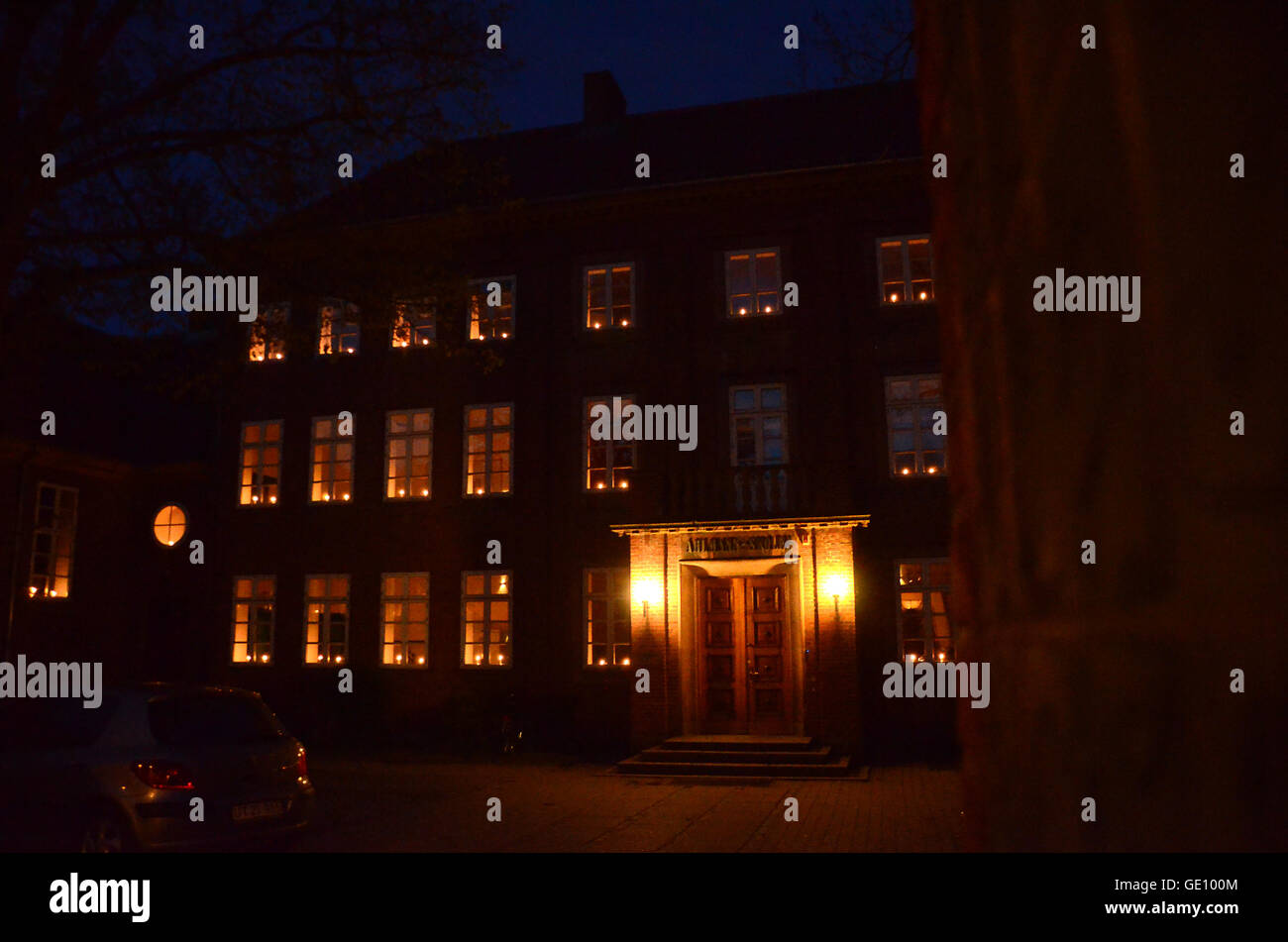Candles in the windows of an old German style school building. The ...