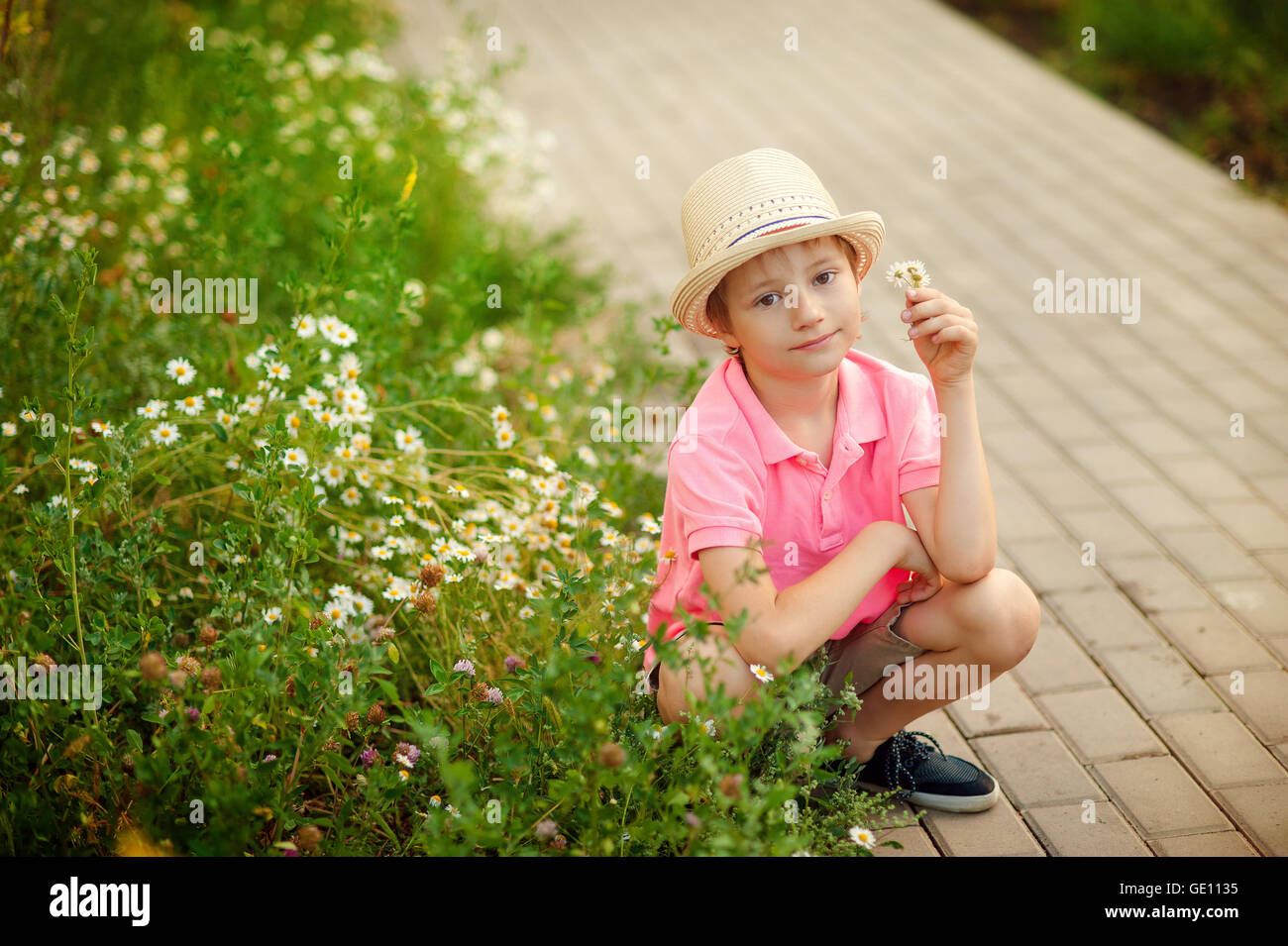 boy sitting in the flowers in the spring time Stock Photo - Alamy