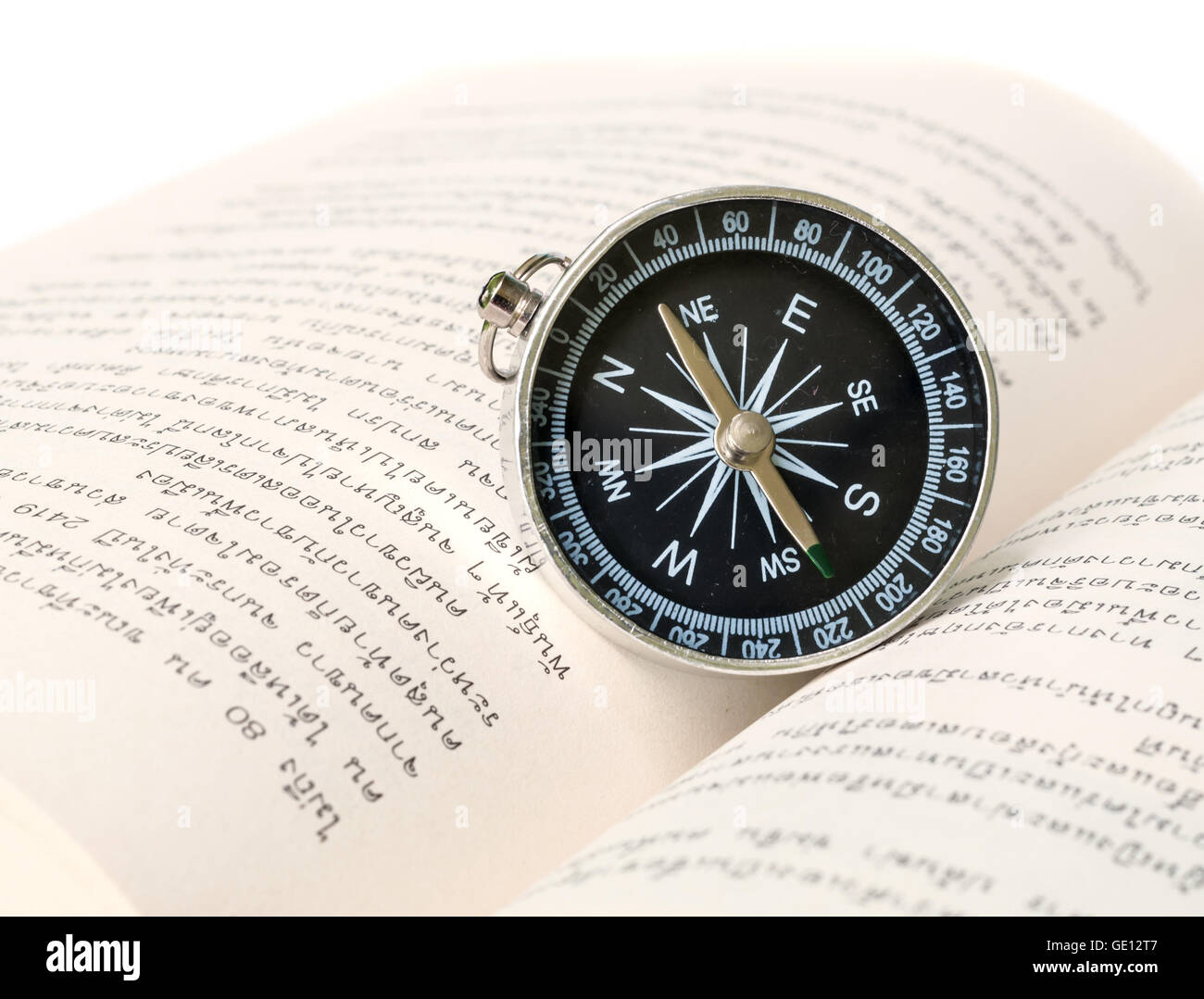 Compass with the book on white background Stock Photo - Alamy