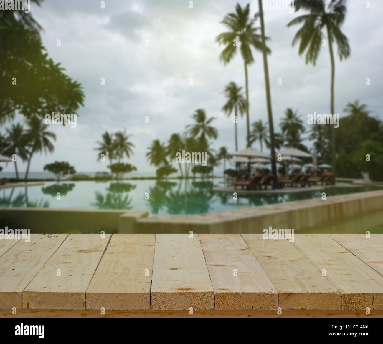 wood table top on blur of swimming pool beach coconut tree - can use to ...