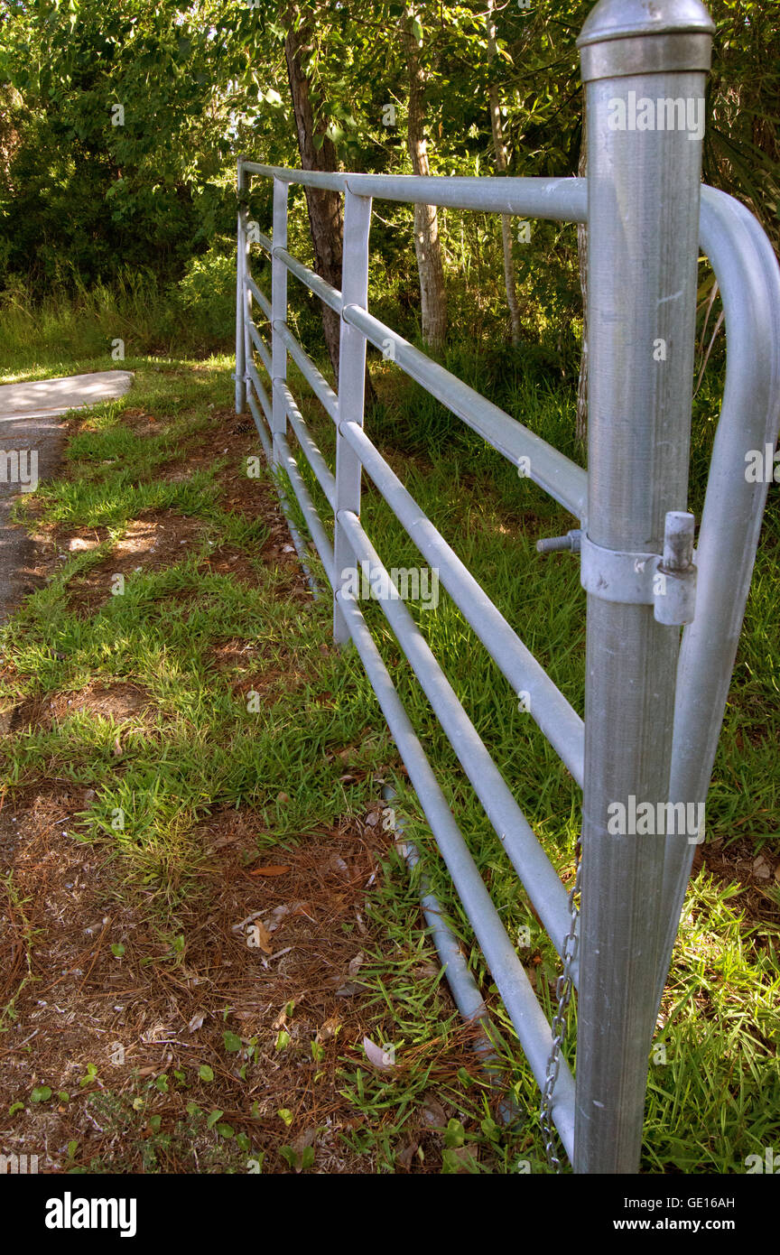 A metal post and a metal on a background of pavement, grass, and ...