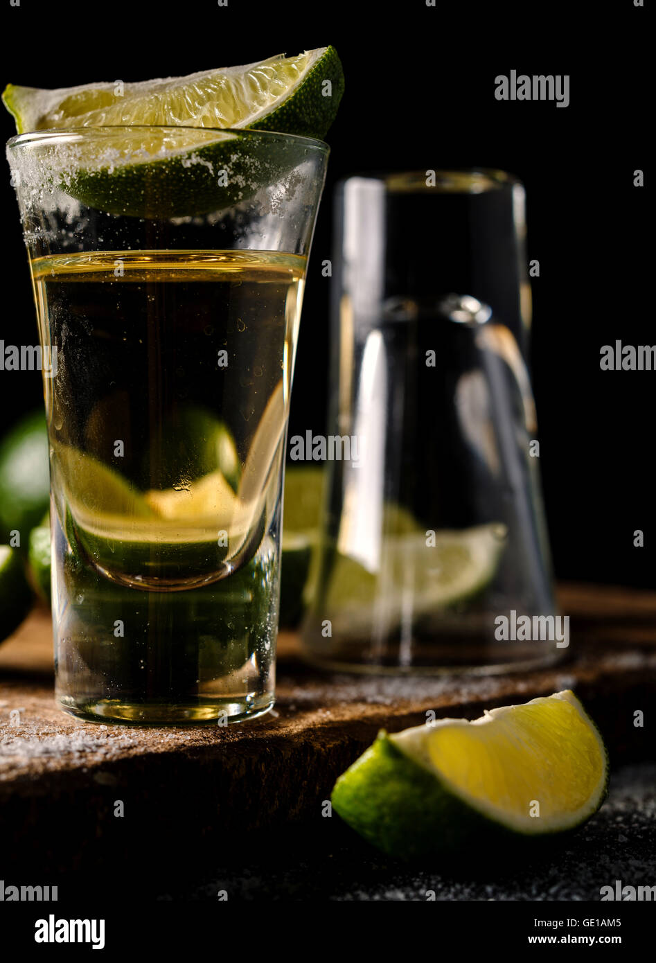 Gold tequila shot with lime. Gold Mexican tequila. Alcohol drink Stock ...