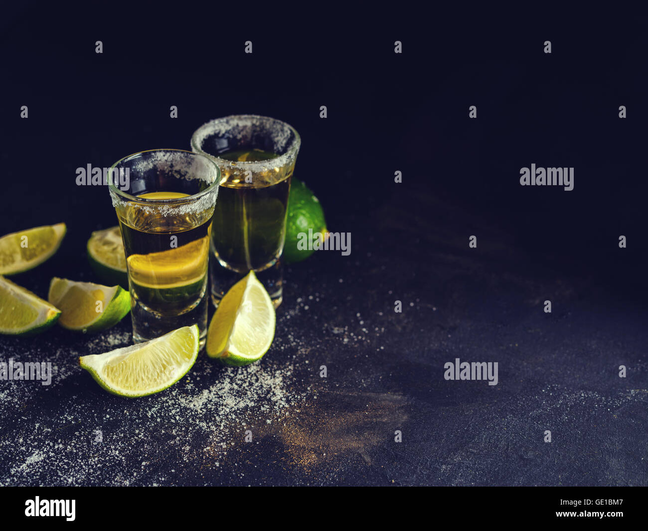 Mexican Gold Tequila with lime and salt on dark table. Toned. Retro ...