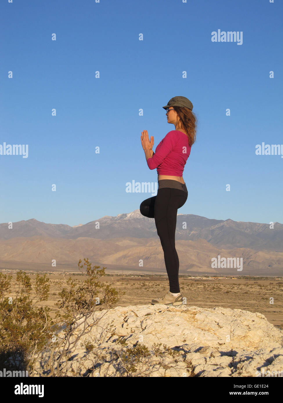 Women doing tree pose on rock in the desert hi-res stock photography ...